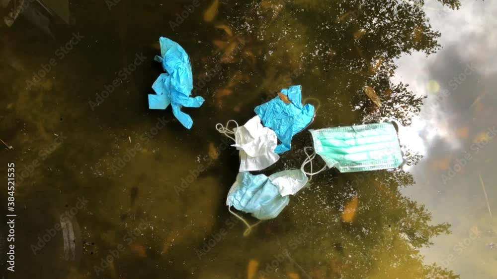 Vidéo Stock Used infectious masks and medical glove floating in dirty ...