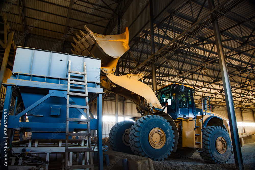 Phosphate fertilisers plant. Caterpillar excavator (bulldozer) loading ...