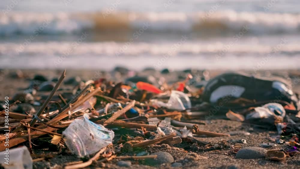 Spilled garbage on the beach of plastic bottles, bags and other garbage ...