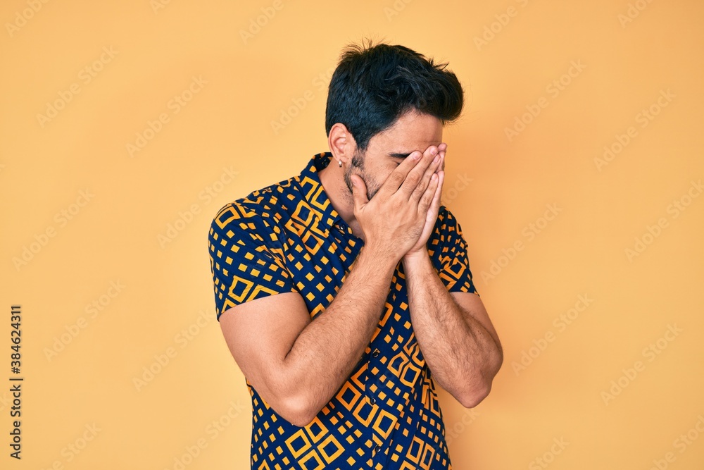 Handsome hispanic man with beard wearing 80s disco style shirt with sad ...