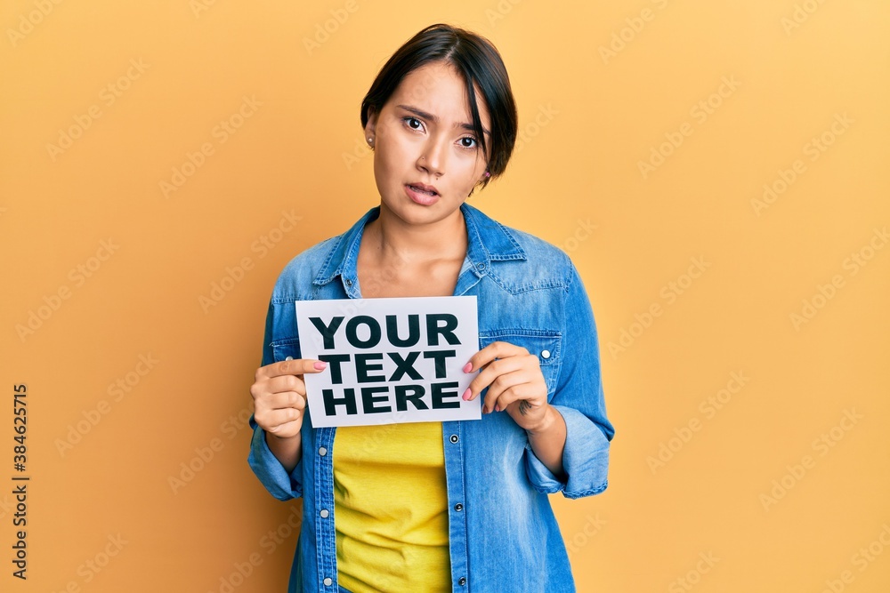 Foto de Beautiful young woman with short hair holding your text here ...