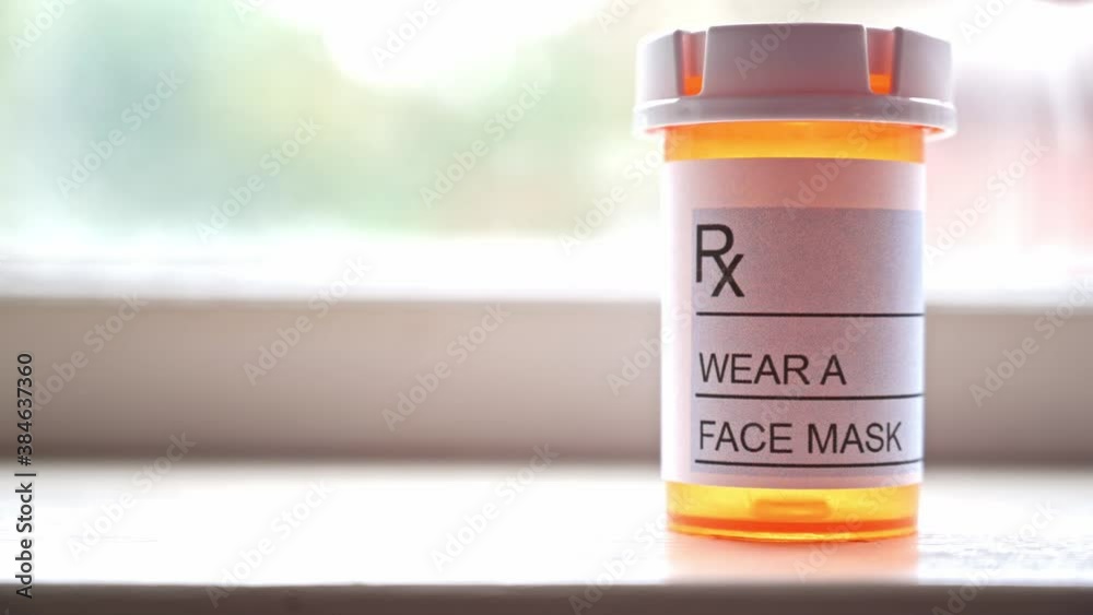A man's hand puts down a prescription bottle with label saying WEAR A ...