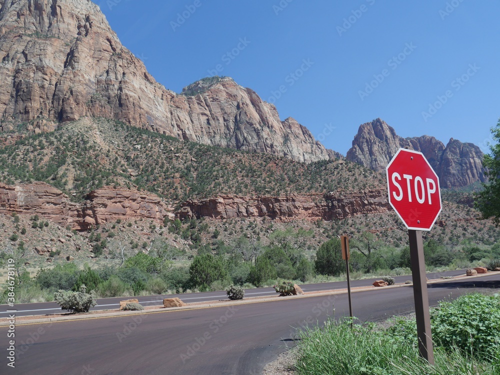 Stop sign on the road side with imposing cliffs and rock formations at ...