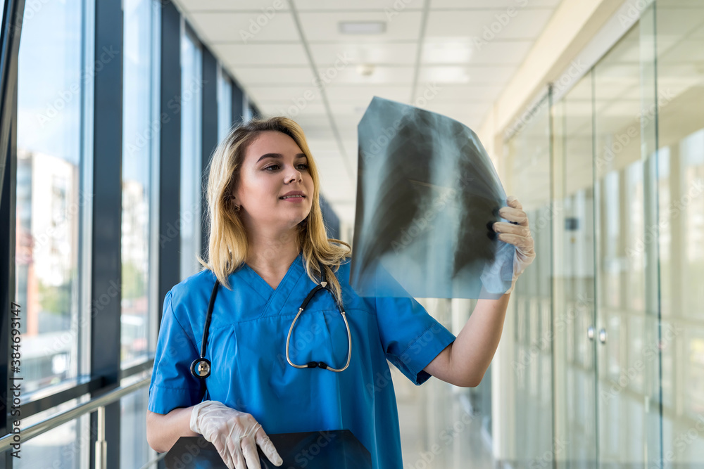 nurse in a blue uniform checks for pneumonia in the xray film of lungs ...