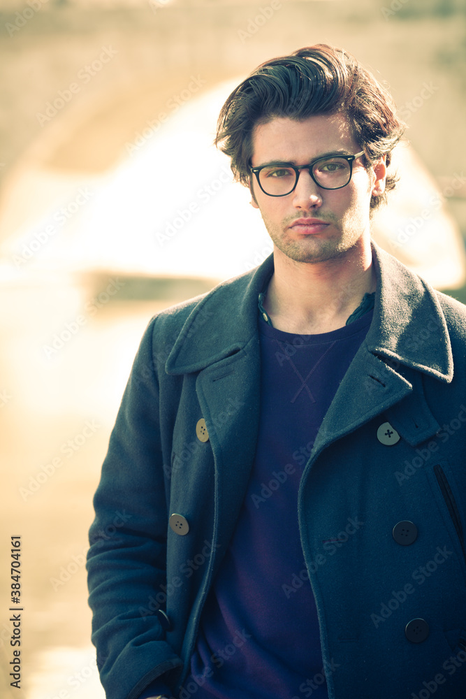 Handsome and charming portrait of a young man with glasses and coat in ...