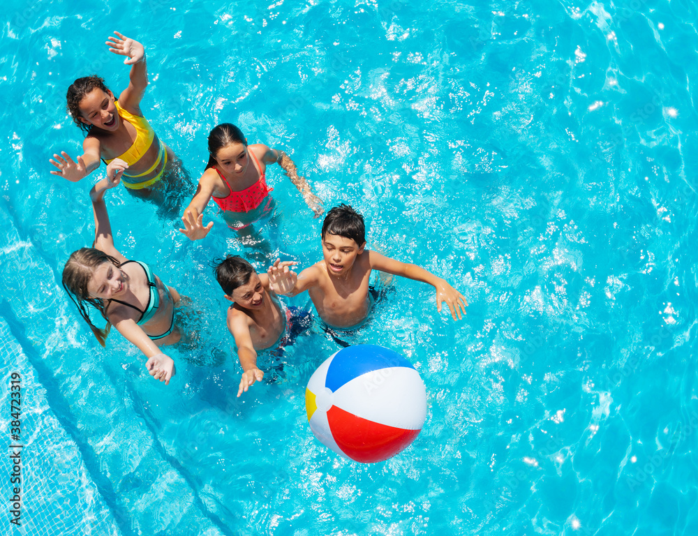 Group of kids in swimming pool play with inflatable ball view from ...