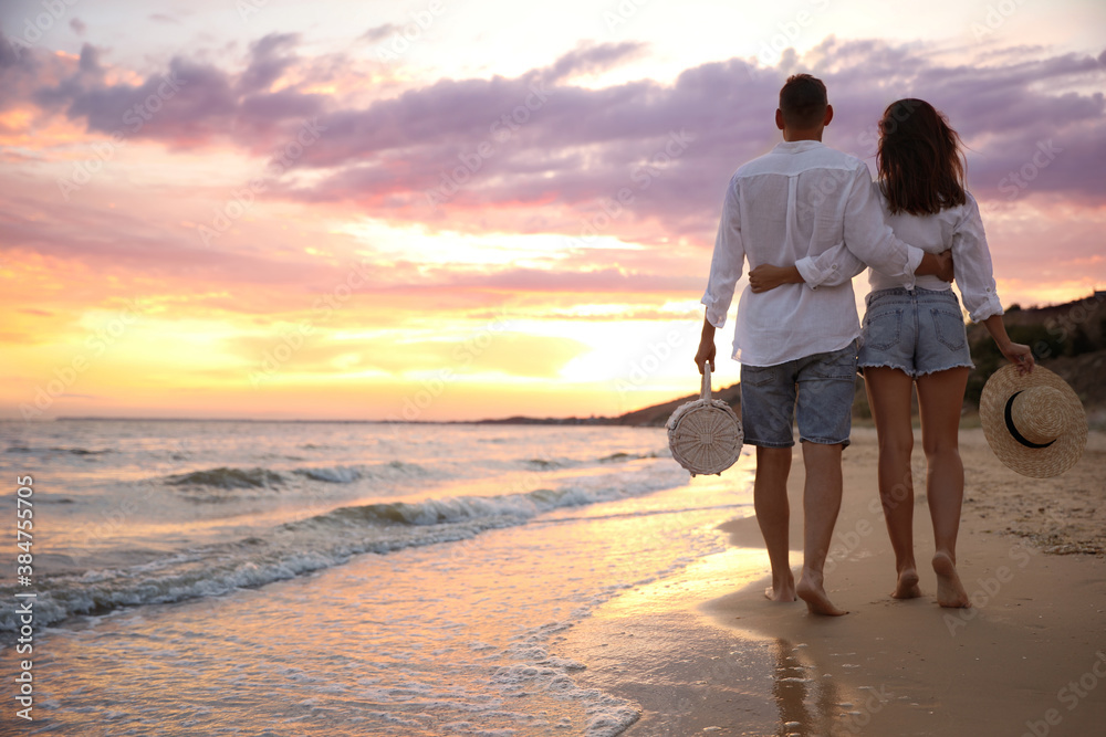 Couple Walking On The Beach At Sunset