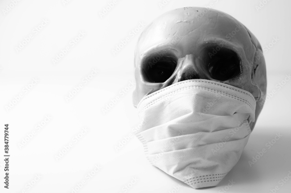 Scary human skull wearing a medical mask, symbolic depiction of death ...