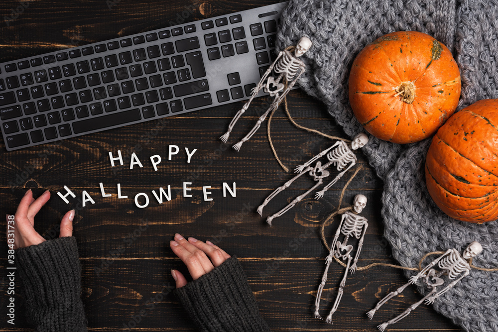 Female hands and Halloween decorations with skeleton and laptop ...