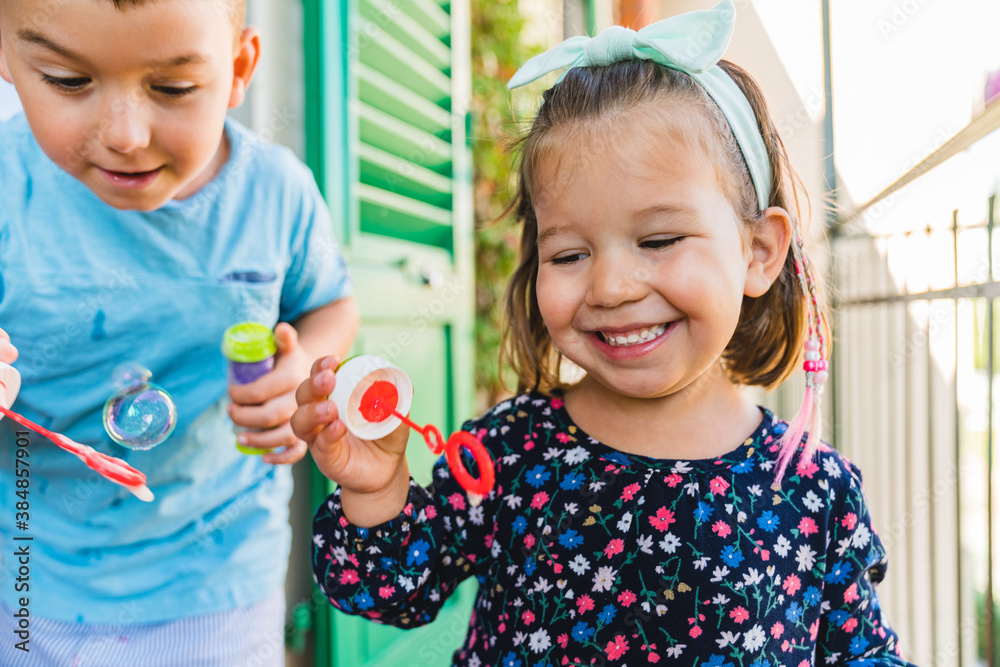 Happy siblings catching bubbles together Stock Photo | Adobe Stock