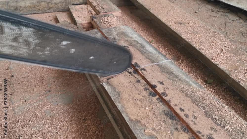Close up of sawing a log with a chainsaw process. Video. Male carpenter ...