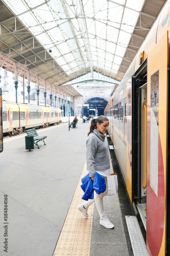 Mature woman boarding a train Stock Photo | Adobe Stock