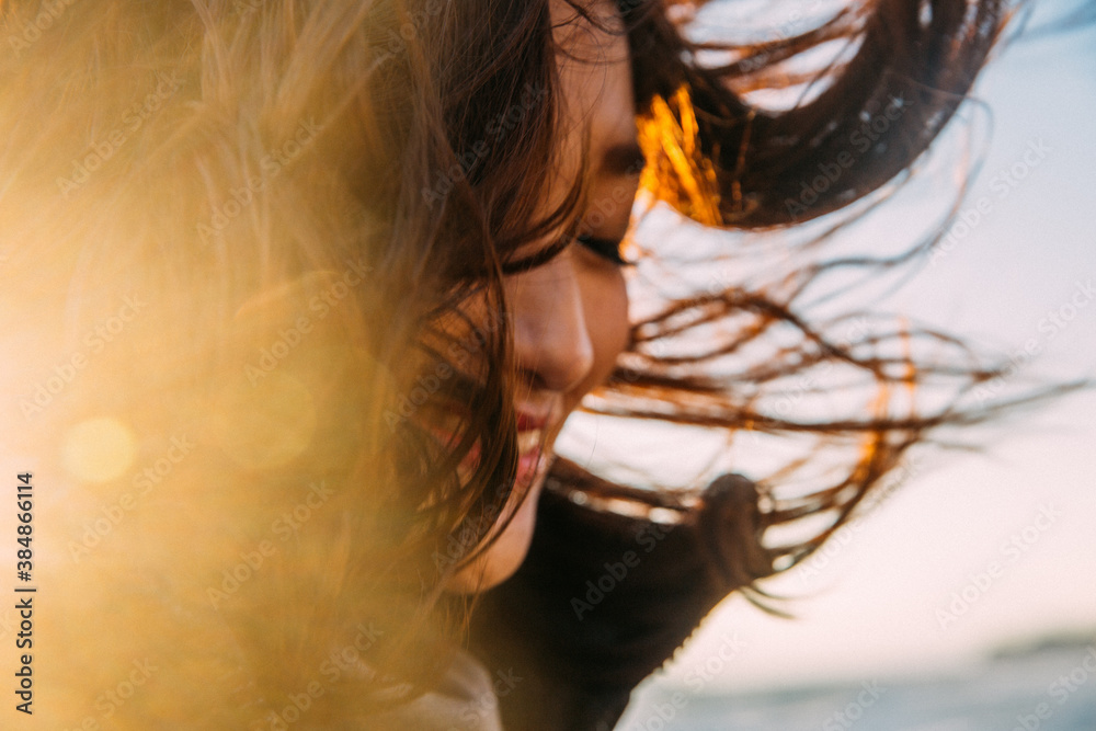 Young women feel winter wind on the beach Stock Photo | Adobe Stock