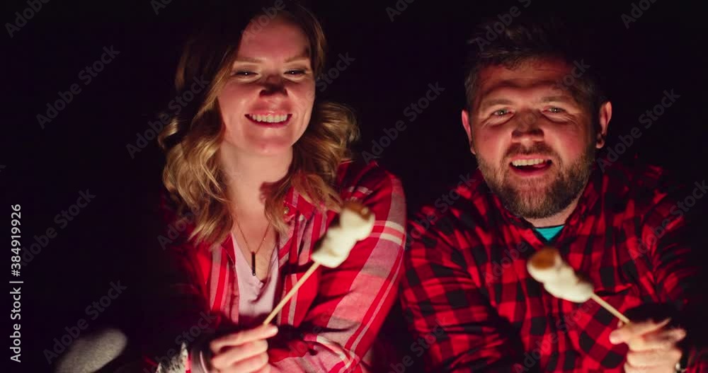 Cinematic view through bright golden flame on romantic couple making ...