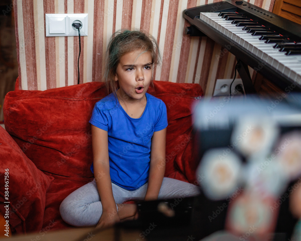 Girl singing song before screen of laptop at home during online class ...
