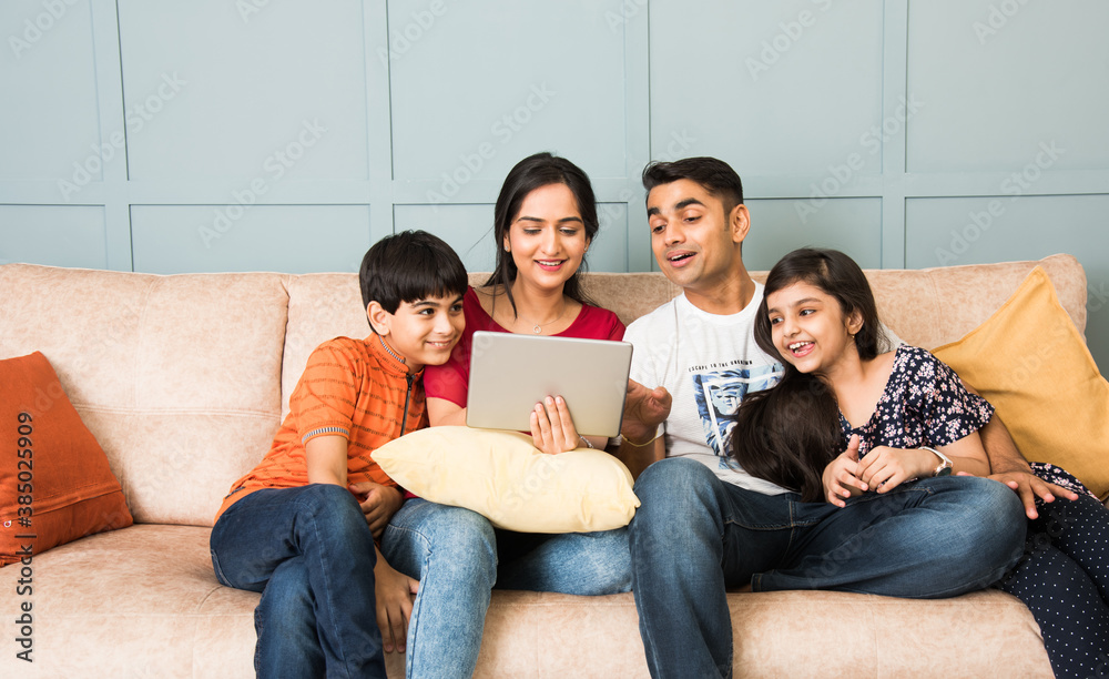 Indian family using smartphone, laptop or tablet, watching movie ...