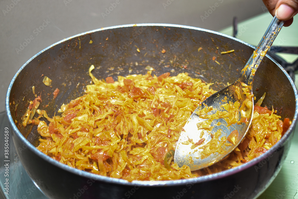 preparing homemade indian style tasty and spicy cabbage curry with ...