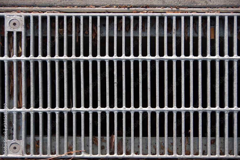 Full frame view from direct above of a section of drain covering metal ...