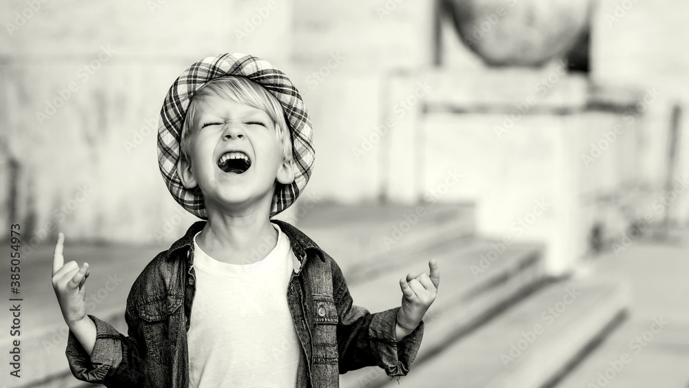 Cute child showing horns up gesture. Excited little boy screaming and ...