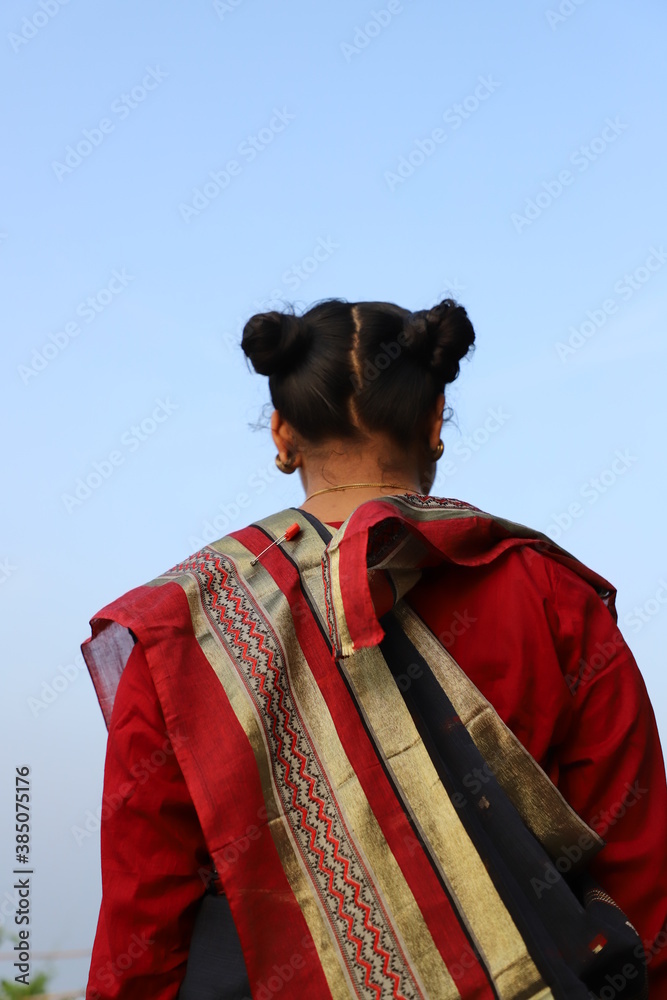 A young teenage southeast Asian girl facing the blue sky wearing ...