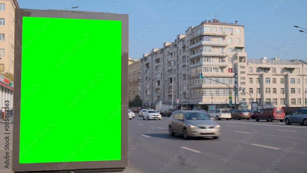 Green screen, chroma key, a billboard on a busy street. Cars move in a ...