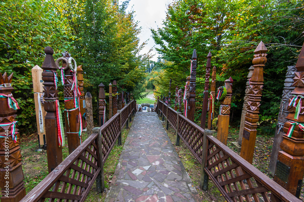 Hand carved wooden posts in row on local memorial park in the memory of ...