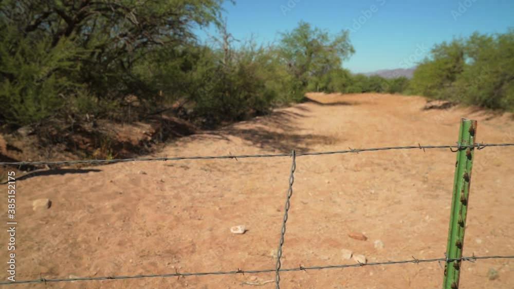 This panning video shows a rustic barb wire fence border in a remote ...