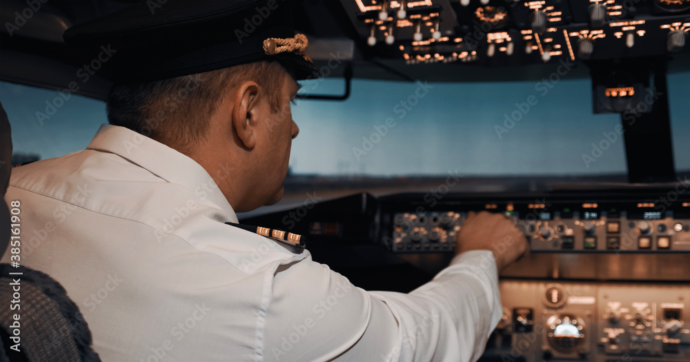 Aircraft captain using control panel in cockpit Stock Photo | Adobe Stock