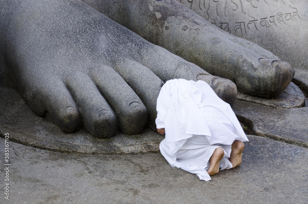 Foto de Jain pilgrim is praying at the feet of the gigantic statue of ...