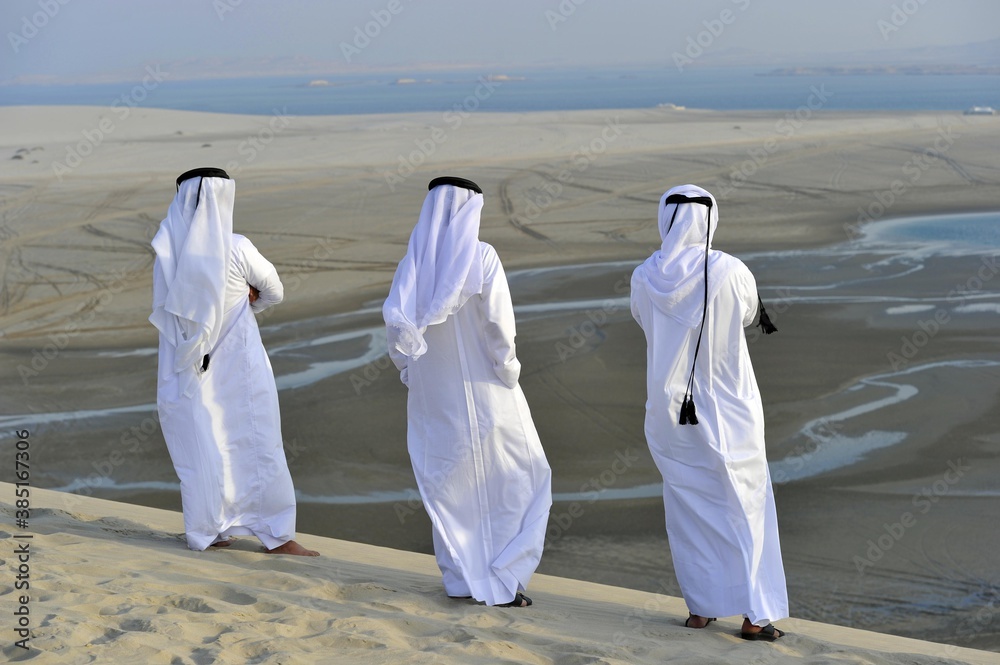 Qatari in traditional clothing with gutra, in front of Khor Al Udeid ...