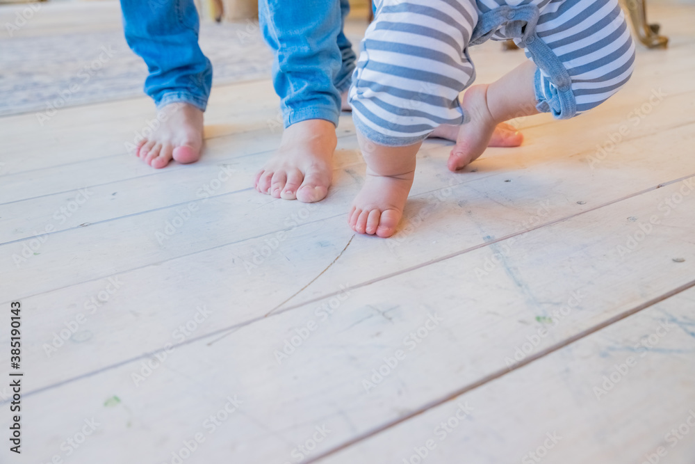 little baby first steps with the help of parents.small and large feet ...