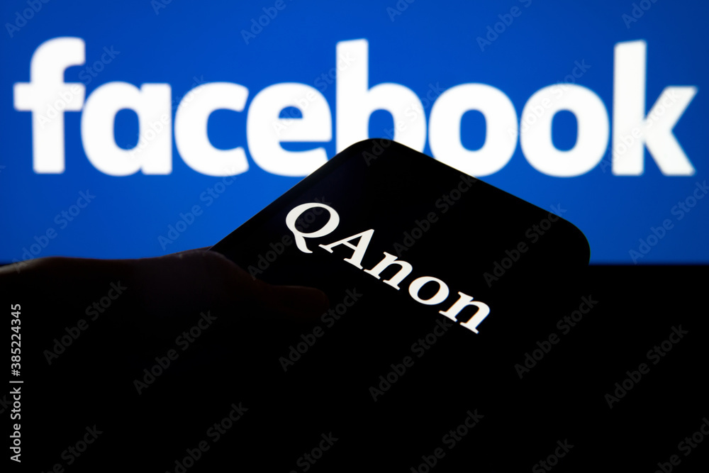 QAnon vs FACEBOOK. QAnon organization logo seen on the smartphone which ...