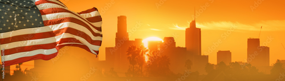 American flag concept. USA Flag over sunrise sun peaking behind city of ...