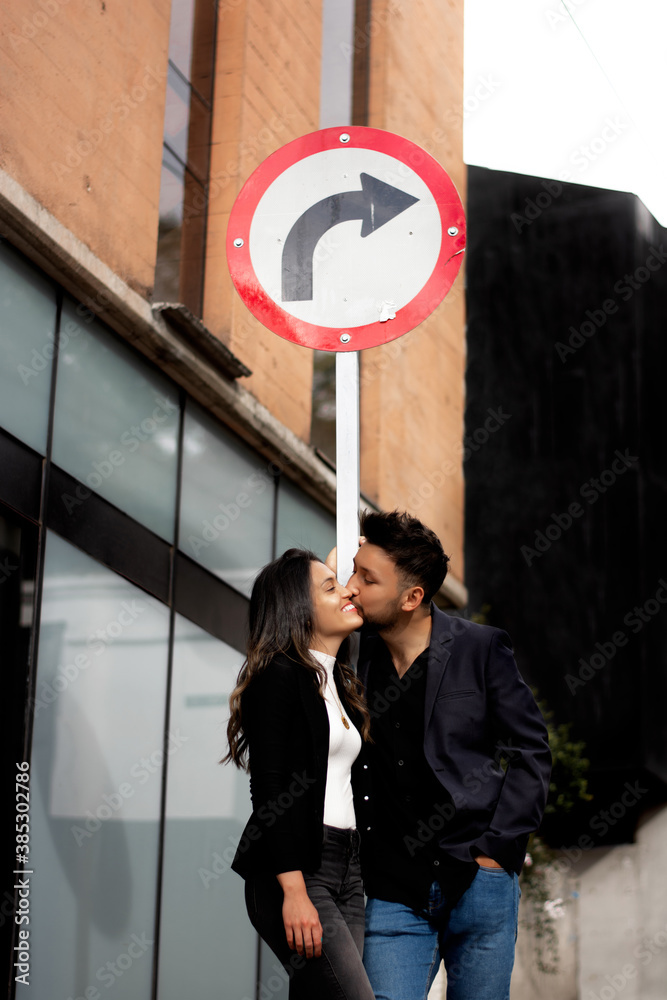hombre dando un beso en la mejilla a su novia bajo una señal de ...