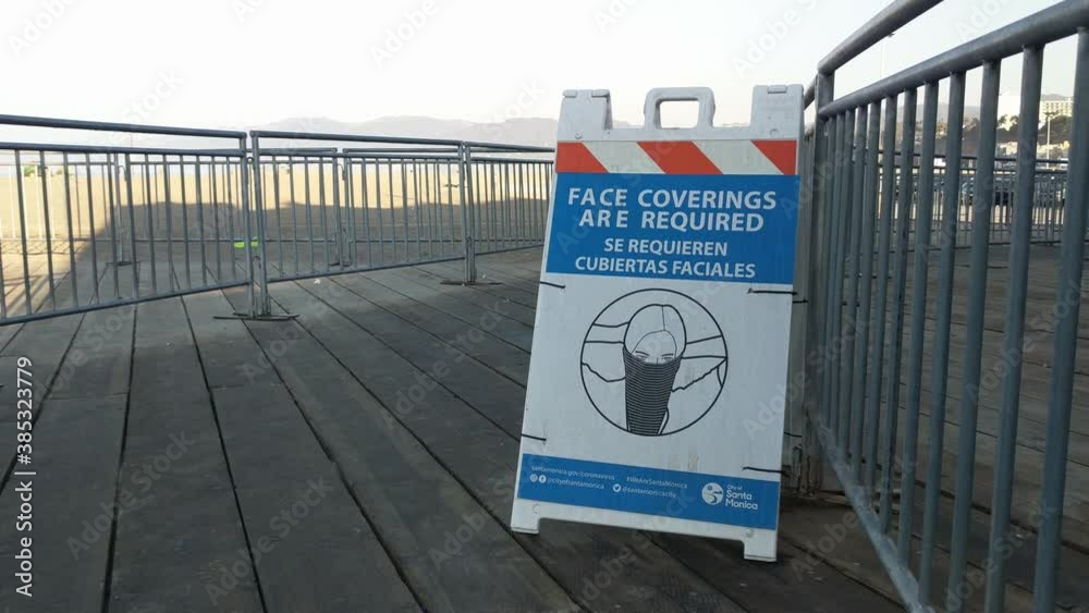 Wear face mask warning sign at Santa Monica pier in Los Angeles. USA ...