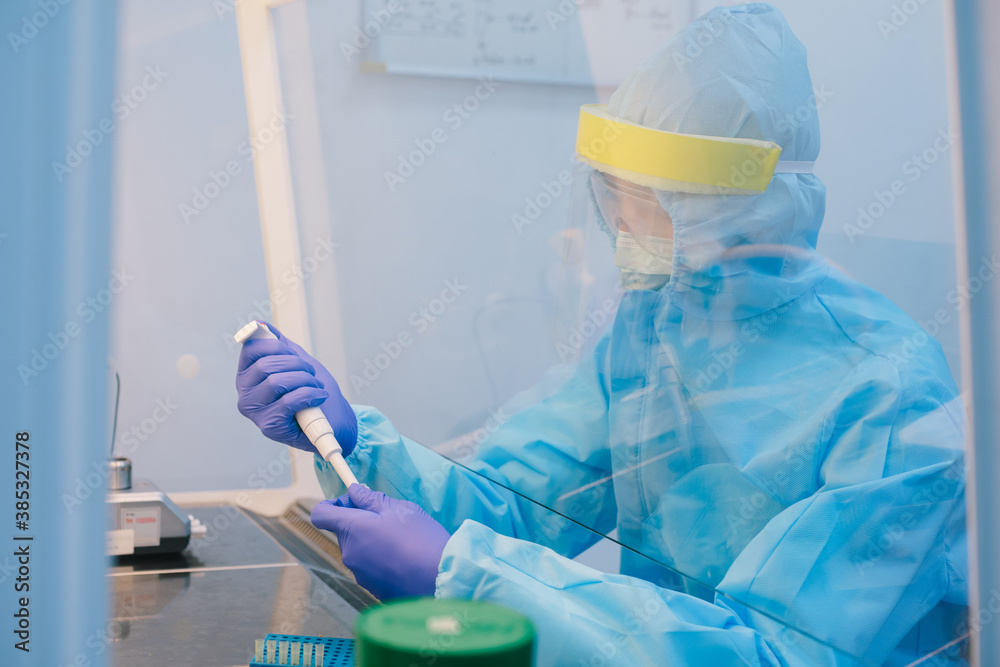 Poster A scientist in PPE safty uniform pipetting sample experiment in ...