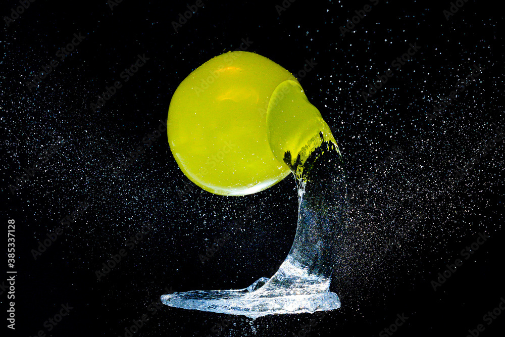 gelber, mit Wasser gefüllter Ballon explodiert Stock Photo | Adobe Stock