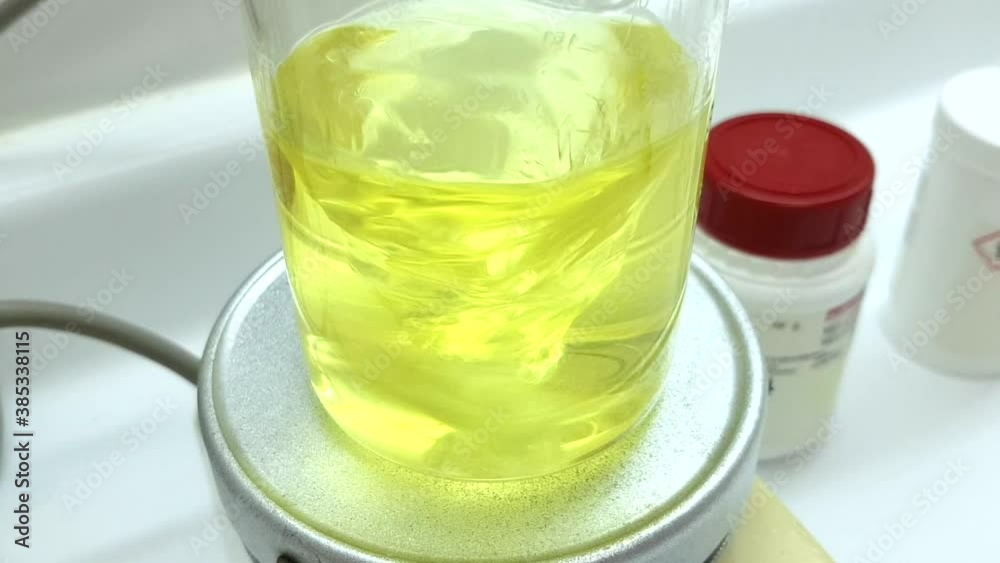 magnetic stirrer mixing yellow chemical solution in beaker Stock ビデオ ...