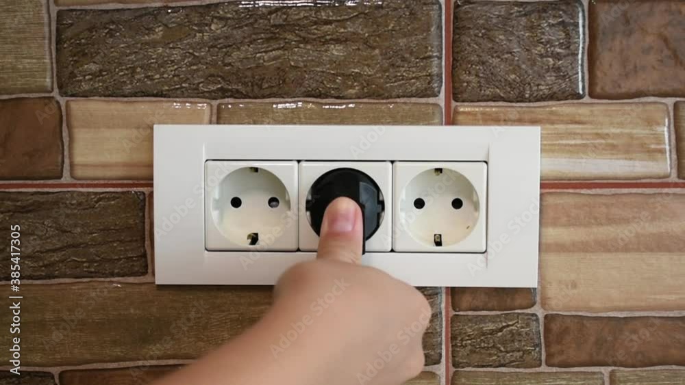 Vidéo Stock Woman's hand connecting a device in a triple power wall ...