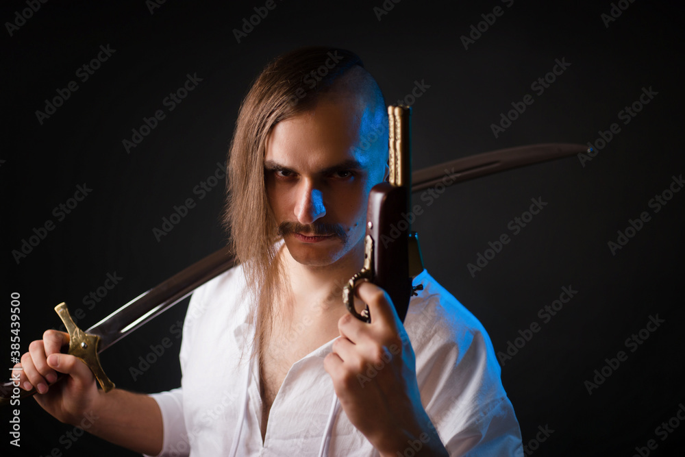 Kozak with weapons in national Ukrainian clothes. A young man with a ...