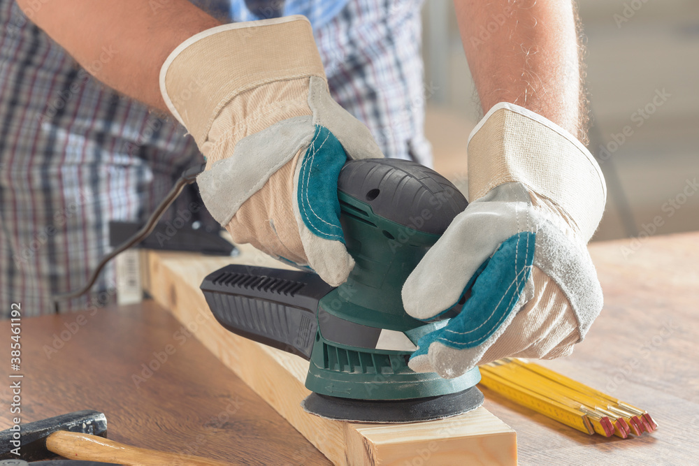 Man sanding a wood with orbital sander Stock Photo | Adobe Stock