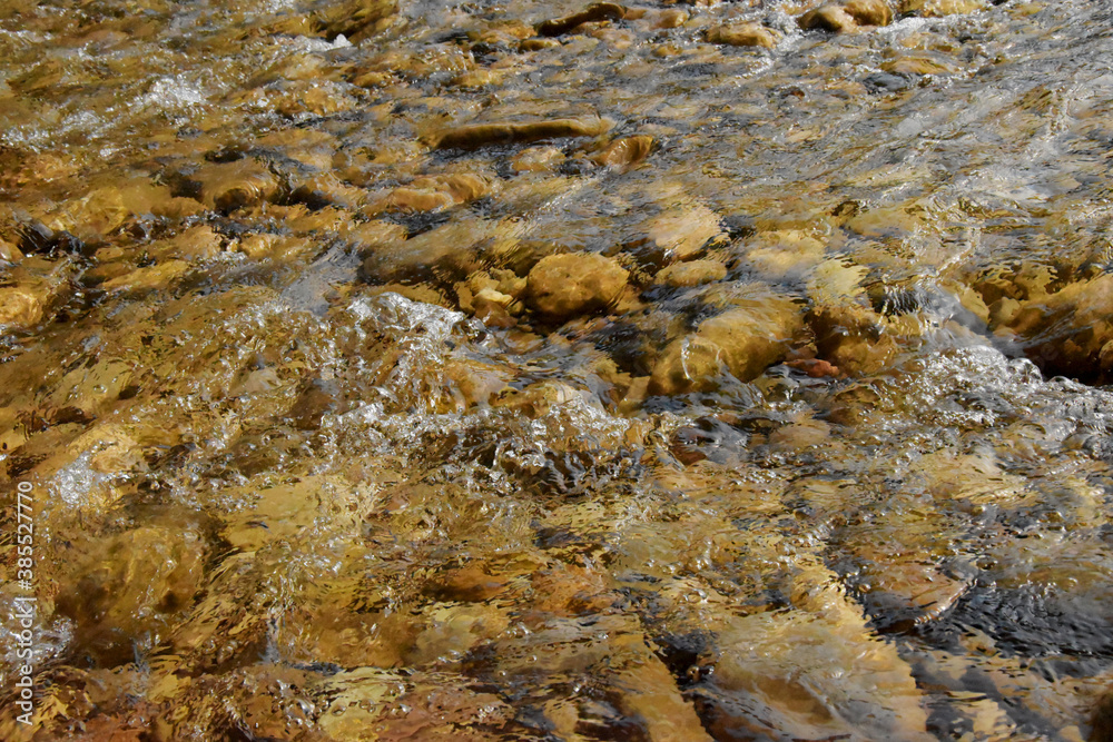 The seething water of the river runs over large and small stones. The ...