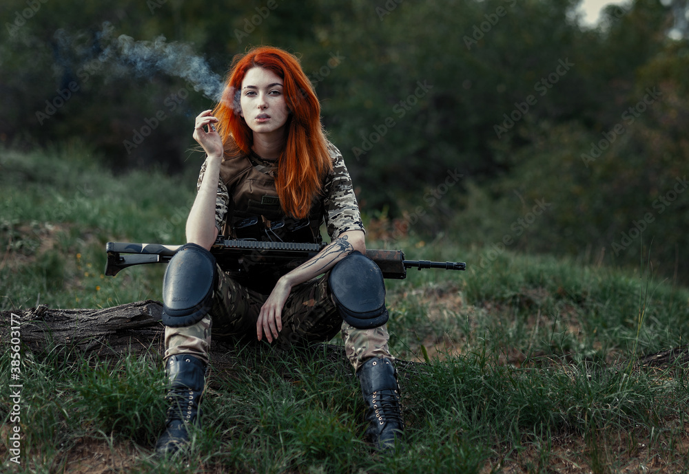 Sniper girl in a green field. Military snipers. The sniper smokes. Red ...