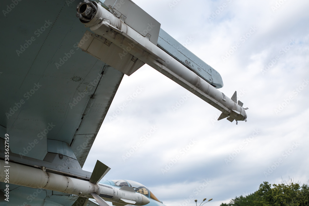Two air-to-air missiles are suspended under the wing of the aircraft ...