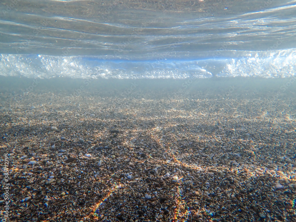 Wave undersea, A wave photographed from under the water in a sandy sea ...