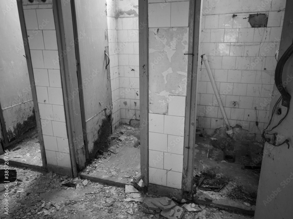 Interior of an old messy abandoned and ruined toilet with cabins ...