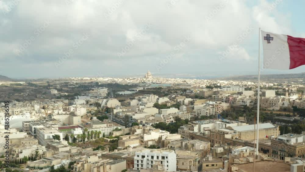 Slow Establishing Shot passing by Flag of Malta waving in revealing ...