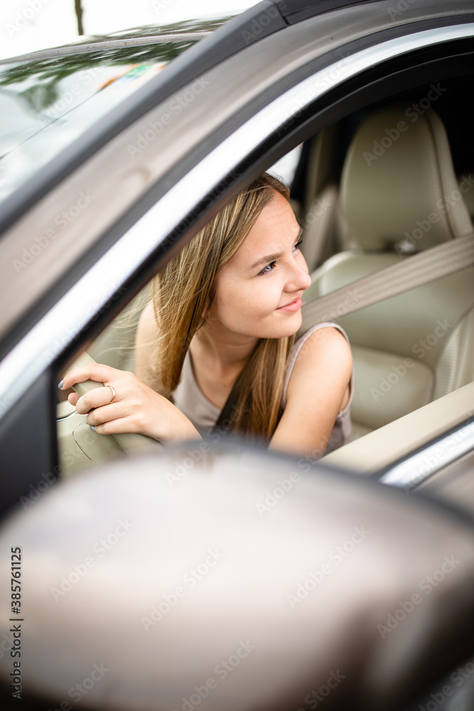 Cute female teen driver enjoying her freshly acquired driving license ...