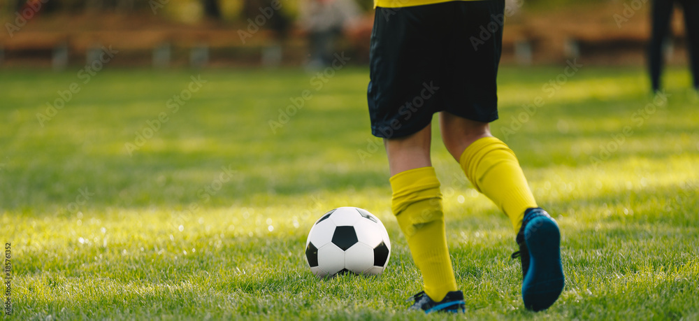 Boy soccer player running after ball. Grass football venue. Young ...