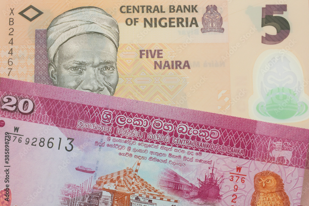 A macro image of a orange, plastic five naira note from Nigeria paired ...